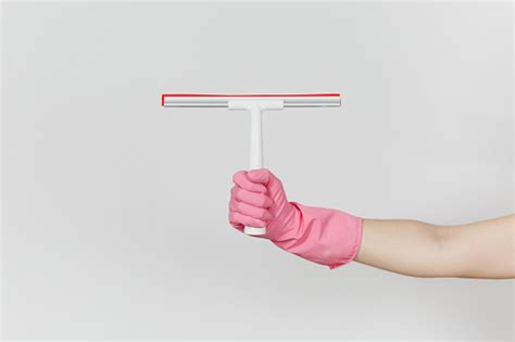 핑크 장갑 가로 흰색 배경에 고립 된 빨간 요소와 함께 표면 청소를 위해 백색 고무 롤러를 보유 하 고 있는 여성 손의 닫습니다 청소 공급 개념입니다 광고에 대 한 공간을