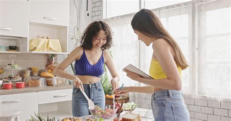 십대 자매 두 명이 집의 부엌에서 야채 샐러드를 만들고 있습니다 가족 휴가 활동 요리에서 행복하게 함께 사는 레크리에이션 요리 연습 20 29세에 대한 스톡 사진 및 기타