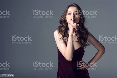 회색에 고립 된 카메라에 침묵 기호를 보여주는 세련 된 드레스를 입고 매력적인 젊은 여자 드레스에 대한 스톡 사진 및 기타 이미지 드레스 우아 젊은 여자 Istock