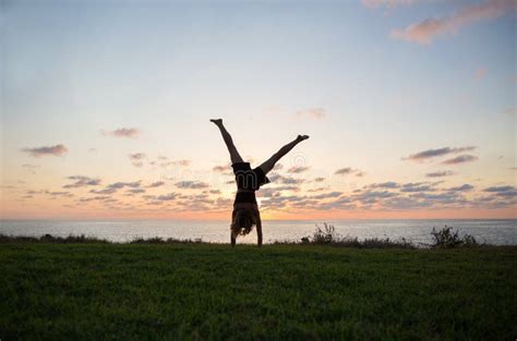 Slender Girl Teenager Makes Flip On Hands Upside Down At Sunset