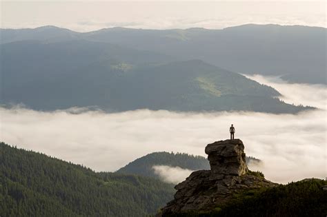 산 골짜기에 높은 바위 형성에 운동 등산 관광의 실루엣 백색 푹신한 구름과 안개로 가득와 상록 숲 산 중턱에서 맑은 하늘 배경으로 덮여 계곡에 대한 스톡 사진 및 기타