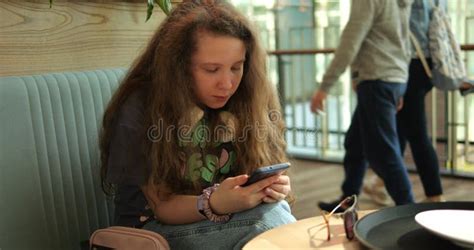 Girl Types On Smartphone Scrolling Through Updates Sitting At Cafe Table Stock Video Video Of