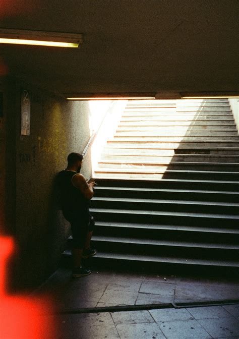 남자는 어두컴컴한 지하철 터널에서 계단을 생각하고 있습니다 사진 Unsplash의 무료 거리 사진 이미지