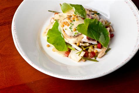 가리비 마늘 버터 샬롯 화이트 와인에 구운 팬 클래식 한 해산물 고급 식사 앙트레 찐 유기농 채소 브로콜리 당근 콜리플라워 레몬과 이탈리아 파슬리로 장식되어 제공됩니다 0