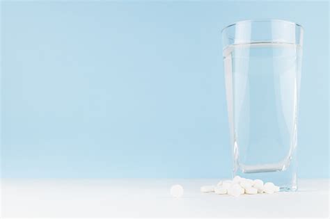 흰색 테이블과 파란 벽에 정제와 물 한 잔 건강 및 예방 테라 피 병 독감 감기 발열 두통 가정 의학 가슴 복사 공간을위한 의료 및 약국 치료 가벼운에 대한 스톡 사진 및