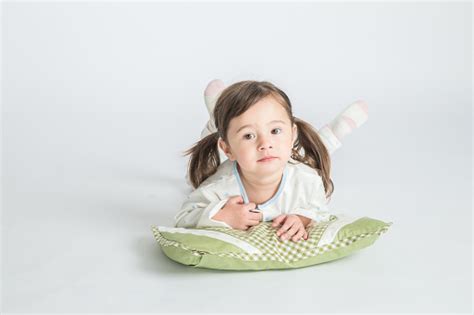 아름 다운 소녀는 흰색 바탕에 바닥에 놓여 있습니다 행복 한 유년 시절 가족에서 복지의 개념 격리 가정 생활에 대한 스톡 사진