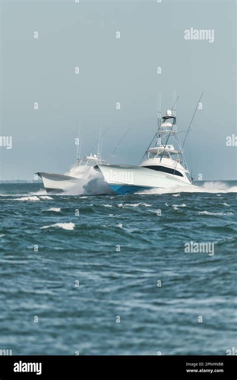 A Pair Of Fishing Vessels Navigating Through The Choppy Waters Of The