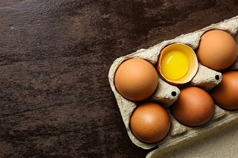 어두운 나무 배경에 재활용 종이로 만든 에코 트레이에 신선한 갈색 계란과 노른자를 가진 깨진 계란 0명에 대한 스톡 사진 및 기타 이미지 Istock