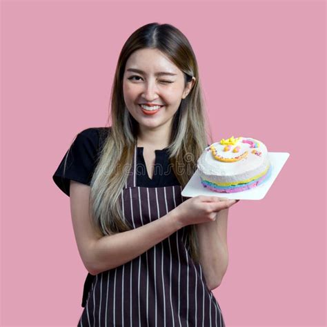 Young Asian Woman With An Apron In Celebratory Or Festive Mood Holding