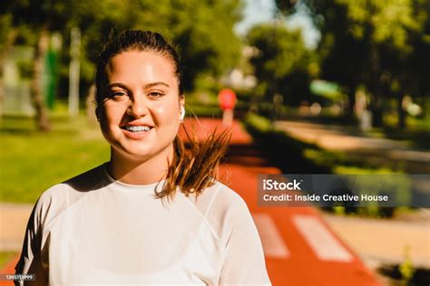 미소 맞는 플러스 크기 통통 한 뚱뚱한 선수 스포티 한 여자 조깅 슬리밍 체중 굽기 칼로리경기장에서 아침 야외에서 건강에 좋지