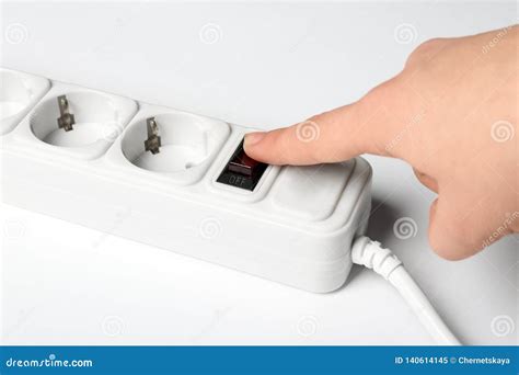 Woman Pressing Power Button Of Extension Cord On White Stock Image
