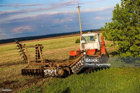 화창한 봄날에 트랙터 쟁기와 하로우가 큰 들판에 착륙합니다 작물을 심기위한 토양을 준비 디스크 쟁기와 트랙터와 토양을 쟁기 건초