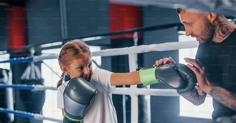 권투 링에서 서로 스파링을합니다 젊은 문신을 한 권투 코치는 체육관에서 귀여운 소녀를 가르칩니다 사진 Unsplash의