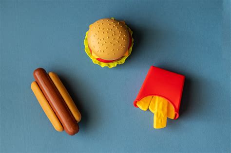 플라스틱 햄버거 샐러드 토마토 파란색 배경에 핫도그와 감자 튀김 수평 방향 어린이 장난감 유해한 인공 식품의 개념 플라스틱 하지 유기 건강하지 않습니다 고기에 대한 스톡