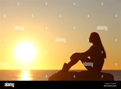 Profile Of A Woman Silhouette Watching Sun On The Beach At Sunset Stock