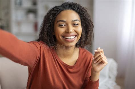 Cheerful Young Black Woman Taking Selfie While Relaxing At Home Stock