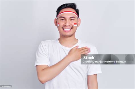 흰 배경에 고립된 8월 17일 인도네시아 독립기념일을 축하하면서 가슴에 손으로 존경의 몸짓을 하는 웃는 젊은 아시아 남성의 초상화 30 34세에 대한 스톡 사진 및 기타