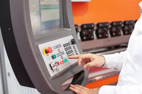 Operator Using An Industrial Cnc Machine Control Panel With Precision And Focus In A