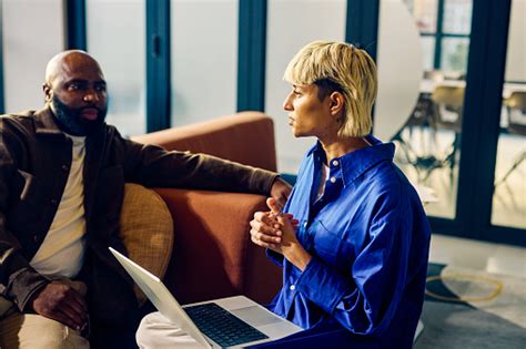 짧은 금발 머리를 한 여성과 창의적인 사무실 환경에서 아프리카계 미국인 남성 간의 전문적인 토론 협업 팀워크와 비즈니스 컨셉의