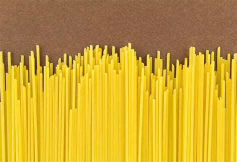 갈색 종이 배경에 원시 이탈리아 파스타 조리되지 않은 전통적인 긴 스파게티 텍스트공간을 복사합니다 갈색에 대한 스톡 사진 및 기타 이미지 Istock