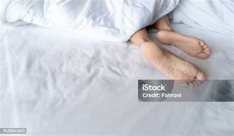 호텔이나 집 침실의 흰색 린넨 담요 아래 맨발로 침대에서 여성 건강한 수면과 휴식 개념 게으른 일요일 아침 하얀 편안한 침대와 이불에서 차가운 잠을 자고있는 여성의 맨발