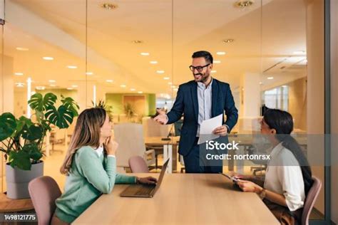 여성 동료들과 회의를 하고 있는 사업가가 사무실에 서서 우아하게 옷을 입고 있다 25 29세에 대한 스톡 사진 및 기타 이미지 25 29세 3 명 30 34세