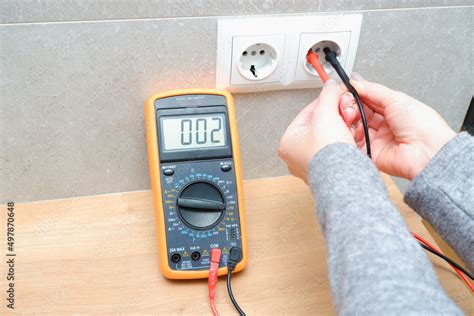 Woman With A Multimeter Check The Voltage Of The Electrical Network Woman Checking Voltage In