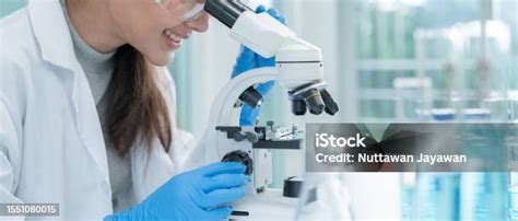 과학자는 첨단 과학 실험실에서 생화학 샘플을 분석합니다 의료 전문 사용 현미경은 바이러스의 미생물 학적 발달을 보입니다 과학 실험실에서의 생명 공학 연구 실험실에 대한 스톡