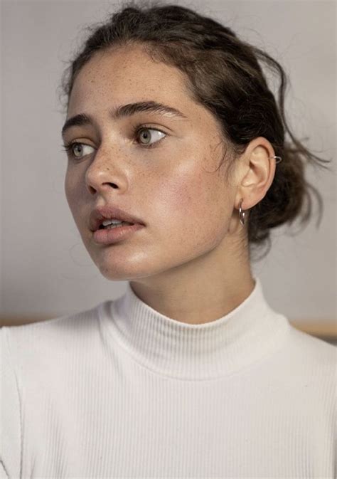 A Close Up Of A Person Wearing A Turtle Neck Sweater And Earring With