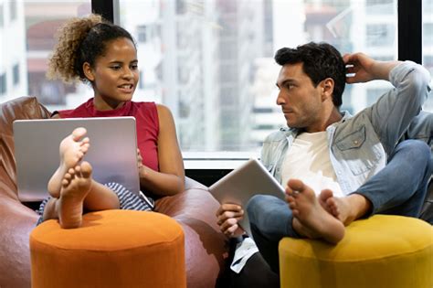 공동 작업 공간에서 함께 브레인 스토밍 창조적 인 디자이너의 그룹 편안한 위치 비즈니스 남자와 젊은 아프리카 계 미국인 여자 앉아 소파에 제시 에 현대 사무실 커피 를