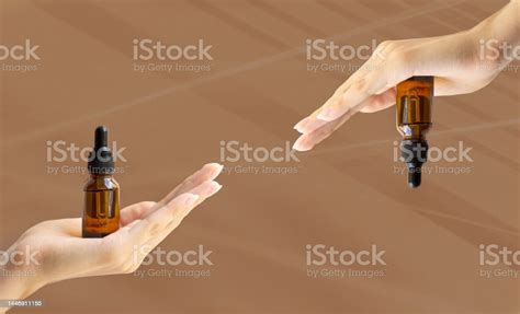 갈색 배경에 화장품 혈청이 있는 호박색 유리 병을 들고 있는 여성의 손 콜라주 햇빛 광선에 콜라겐이 있는 스포이드 뚜껑이 있는 용기의 모형 스킨 케어 개념 액체에 대한 스톡