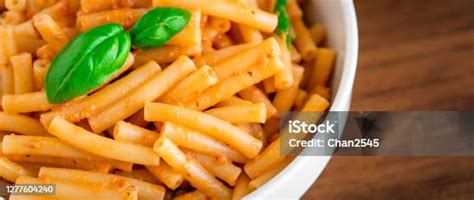 건강한 유기농 이탈리아 마카로니 홈메이드 신선한 파스타 스파게티 국수 요리에 바질 토마토 마늘 페퍼 소스와 비건 채식 레시피를 나무 빈티지 테이블에 얹은 바질 0명에 대한