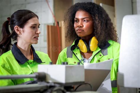 Industrial African Curly Hair Woman Worker In Safety Vest Discussing
