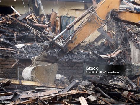 철거 현장에서 작업하는 유압 분쇄기 굴삭기 기계는 먼지와 연기로 연소된 잔해를 치우는 작업 건설 기계류에 대한 스톡 사진 및 기타 이미지 건설 기계류 건설 산업 건설