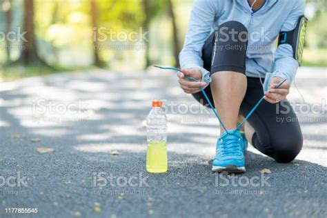 공원에서 운동화를 묶는 젊은 운동 선수 여성 외부 도로에서 조깅을 할 준비가된 여성 주자 아침에 는 아시아 피트니스 걷기 및 운동 웰빙 및 스포츠 컨셉 과체중에 대한 스톡
