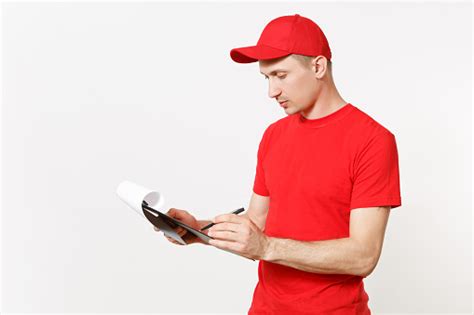 흰색 배경에 고립 된 빨간 유니폼에 배달 남자 남성 모자 T셔츠로 택배 또는 대리점 펜 종이 클립보드를 들고 빈 빈 시트와 문서 작성 공간에 복사 합니다 고용과 노동에 대한