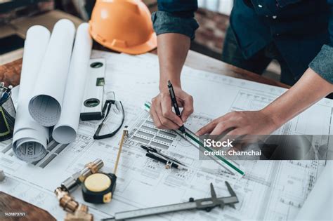 사무실 책상과 계산기 삼각형 눈금자 안전 안경 나침반 블루프린트의 버니어 캘리퍼에서 도면 검사 및 쓰기로 작업하는 엔지니어링 엔지니어 건축가 산업 및 공장 개념 35 39