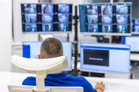 Security Officer Monitoring Multiple Surveillance Screens In A High Tech Control Room For Safety