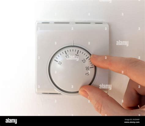 A Man Turning The Thermostat Dial Heating And Cost Of Energy Concept Stock Photo Alamy