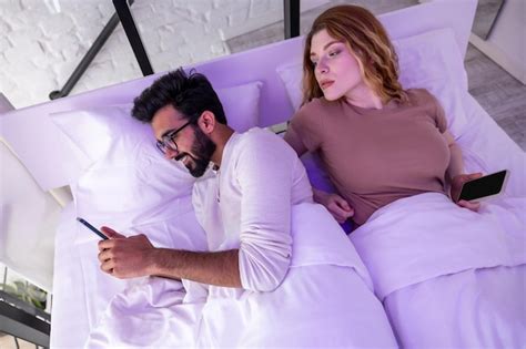 Premium Photo Jealous Young Adult Woman Spying Her Husband Mobile Phone While He Checking
