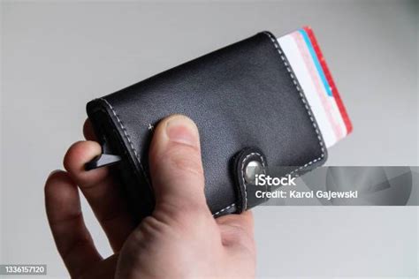 스마트 미니멀 한 지갑 카드 이젝터 2 고립된 흰색 배경에 신용 카드를 꺼내검은 가죽 지갑을 들고 남자의 손을 닫습니다 Rfid 보호 기능이 있는 패셔너블하고 슬림한 지갑