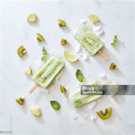 라임 아이스크림 Lollywith 키 위 신선한 민트 잎 얼음 조각 라임 키 위와 텍스트 위한 공간 회색 대리석 배경에 한 조각의 음식 패턴입니다 평면 배치 건강한 생활