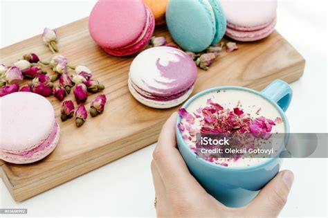 아름다움은 Macarons 나무 책상에 프랑스어와 손을 잡고 흰색 배경 테이블에 카푸치노의 블루 컵 경관에 대한 스톡 사진 및 기타 이미지 Istock