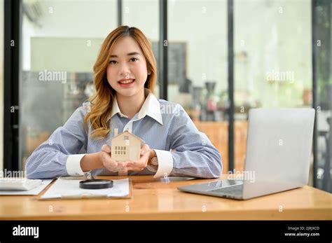 Beautiful Young Asian Female Real Estate Agent Or Realtor Holding Or