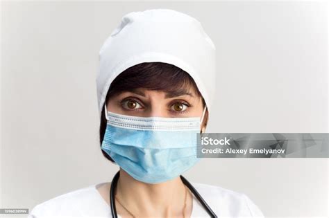 의료용 마스크와 갈색 눈을 가진 모자를 쓴 여성 의사의 얼굴 클로즈업 건강 진단에 대한 스톡 사진 및 기타 이미지 건강 진단 건강관리와 의술 눈 신체 부분 Istock