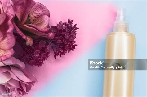 스프레이에서 꽃의 냄새입니다 핸드 스프레이 핑크 배경에 라일락 꽃의 향수의 세련 된 병을 들고 창의적인 최신 유행 플랫 텍스트 위한 공간을 놓으십시오 현대적인 이미지입니다