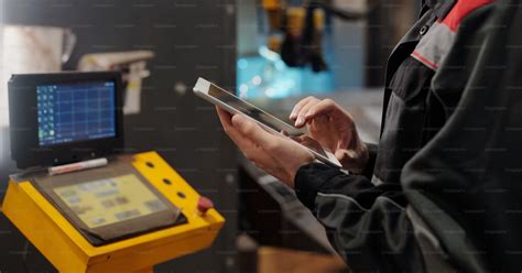 보호 작업복을 입은 젊은 현대 엔지니어가 디지털 태블릿을 들고 온라인 기술 데이터를 스크롤한다 사진 Unsplash의 공장 이미지