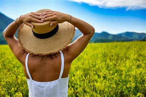 흰 드레스와 밀짚 모자를 쓴 아름 다운 여자가 겨자 밭에 서서 경치를 볼 수 있습니다 겨자에 대한 스톡 사진 및 기타 이미지 겨자 경관 드레스 Istock