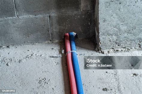 파란색과 빨간색 플라스틱 골판지 튜브가 바닥을 가로질러 뻗어 있습니다 건물의 수리 또는 건설 중에 열 및 물 공급의 임시 통신 0명에 대한 스톡 사진 및 기타 이미지