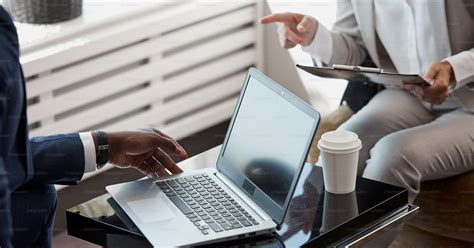 알아볼 수 없는 비즈니스 여성과 남성이 계획과 전략에 대해 논의합니다 남자가 노트북을 들고 앉아 있는 동안 여자는 문서를 들고 있다 사진 Unsplash의 사무실 이미지